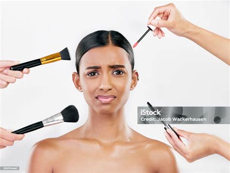 메이크업 브러쉬 불안 아름다움을 가진 여자는 빛나고 하얀 배경에 미용사에게 압도당한다 화장품 도구 및 손에 대한 의심은 스튜디오