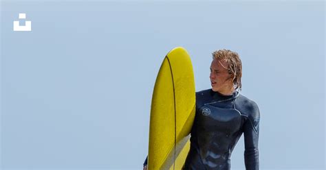 Homme Tenant Une Planche De Surf Jaune Photo Photo Malibu Gratuite