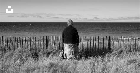 낮 동안 수역 근처의 나무 울타리에 서 있는 검은 재킷을 입은 남자 사진 Unsplash의 무료 여자 이미지