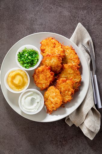 감자 팬케이크 Latkes 또는 Boxty와 사 우 어 크림 요구르트 사과 소스와 잘게 다진된 녹색 양파 회색 돌 배경에서 소스