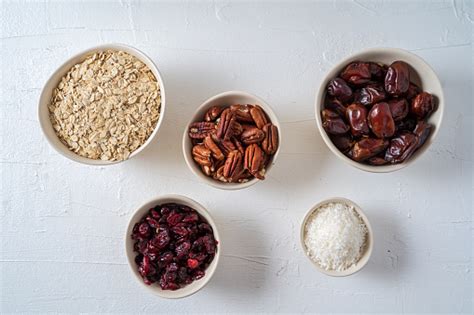 건강 한 유기농 에너지 공을 준비 하기 위한 재료날짜 말린 살구 귀리 플레이크 건포도 말린 크랜베리 피칸 견과류 흰색 바탕에 코코넛 부스러기 0명에 대한 스톡 사진 및 기타