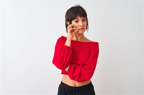 고립 된 흰색 배경 입과 입술 위에 서있는 빨간 여름 티셔츠를 입은 젊은 아름다운 여성은 손가락으로 지퍼로 닫습니다 비밀과 침묵 금기 이야기 T 셔츠에 대한 스톡 사진 및