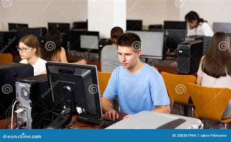 Smart Male Teen Learning Computer Science While She Is Using A PC In The Computer Classroom