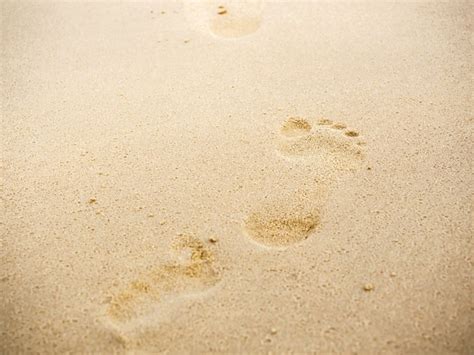 복사 공간이 있는 해변 모래 발자국 모래 해변 배경에서 맨발로 걷는 인간의 발자국을 닫습니다 여행 여름 배경 개념입니다 프리미엄 사진