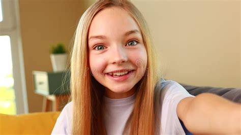 Pre Teen Girl Making Selfie Photos On Her Smartphone In Cozy Living
