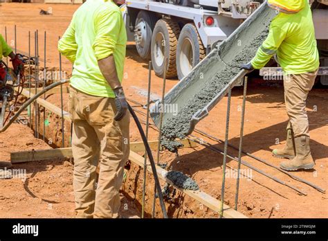 Construction Worker Using Concrete Vibrator For Compacting Cement At Pouring Concrete To