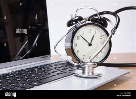 Stethoscope Examining Broken Laptop With Alarm Clock Standing Beside Stock Photo Alamy
