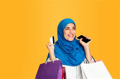 노란 스튜디오 배경에 고립 된 젊은 무슬림 여성의 초상화 가리키기에 대한 스톡 사진 및 기타 이미지 가리키기 갈색 머리