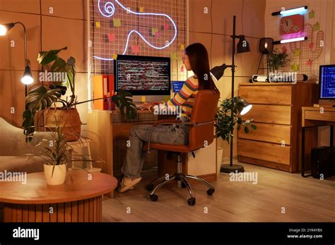 Female Programmer Working With Computer In Office At Night Stock Photo