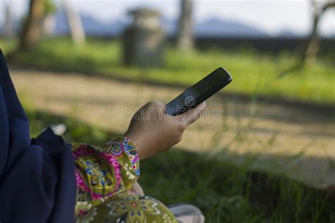 Muslim Girl Wearing Religious Dress And Hijab Using Mobile Phone Stock