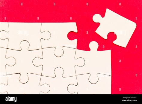 Bodegón con una white jigsaw puzzle incompleto sobre un fondo rojo