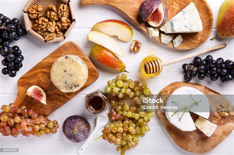 블루 치즈 브리 치즈 포도 무화과 배 꿀 과일 흰색 테이블에 견과류와 트 러 플 하드 치즈 치즈 플레이트 최고의 볼 수 있습니다