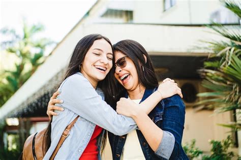 Mulheres hispânicas se abraçando enquanto riem o conceito de amizade Foto Premium