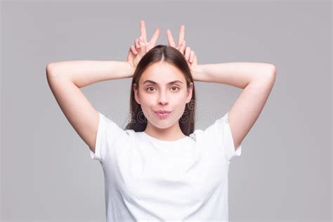 Young Woman Doing Funny Gesture With Finger Over Head As Bull Horns