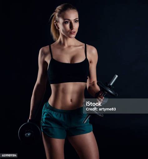 검은 배경 스튜디오에 아령과 스포츠에서 귀여운 운동 모델 소녀 이상적인 여성 스포츠 그림 완벽 한 조각된 근육과 꽉 시체와 함께 피트 니스 여자 건강한 생활방식에 대한 스톡
