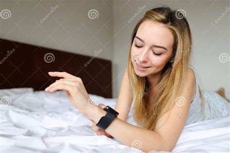 Chica Joven Que Miente En Cama Con El Reloj Elegante Fondo Blanco De