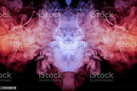 유령 머리의 형태로 신비한 모양의 보라색과 파란색 연기의 멀티 컬러 패턴 또는 검은 고립 된 배경에 이상한 생물 파도와 증기의