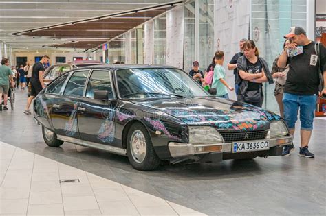 A Sleek Angular Car Sits Indoors With Its Hood Propped Open Showcasing Its Engine Bay The