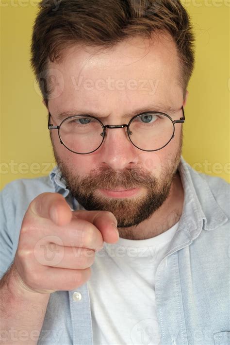 Man With A Beard And Glasses Strictly Looks And Points Fingers On A