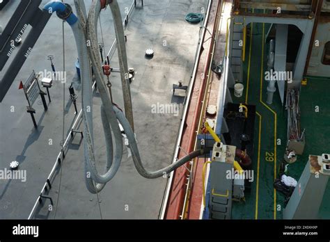 Fuel Hose Of Bunker Barge Attached To Crane And Connected To Container
