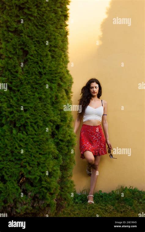 Portrait Of A Fashionable Young Woman With Long Curly Hair Wearing A