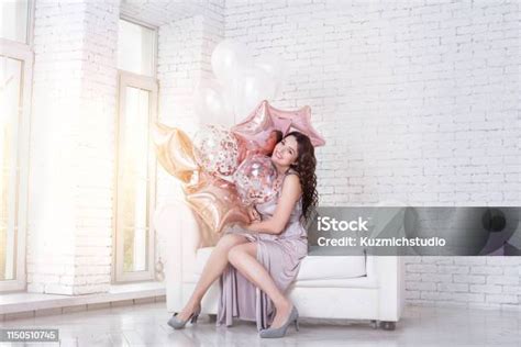 밝은 인테리어에 흰색 소파에 분홍색 풍선 긴 유행 축제 드레스에 젊은 성인 아름 다운 여자 아름다움에 대한 스톡 사진 및 기타