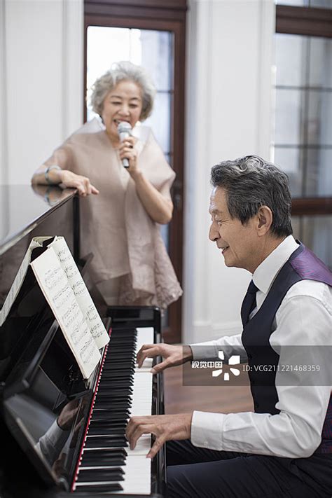老年贵族夫妇一起唱歌弹钢琴图片素材
