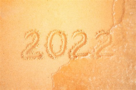 열대 해변에서 모래로 쓰여진 2022 연도 변화의 개념 바다 파도가 비문을 씻어냅니다 따뜻한 나라에서 새해 연휴를 축하합니다 0
