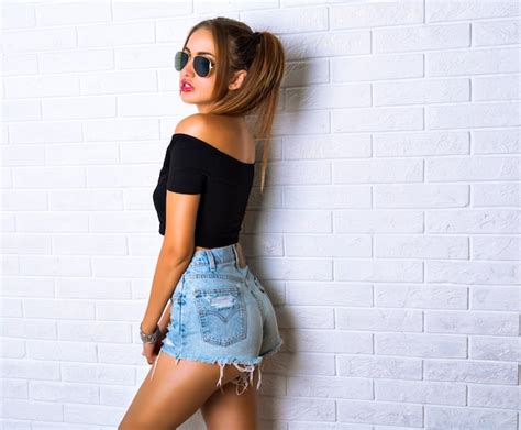 Femme Brune Sexy Posant Au Mur De Briques Urbaines Corps Coupe Incroyable Mini Short En Jean