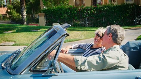 Senior Couple Enjoying Summer Day Trip Out Driving In Car Together