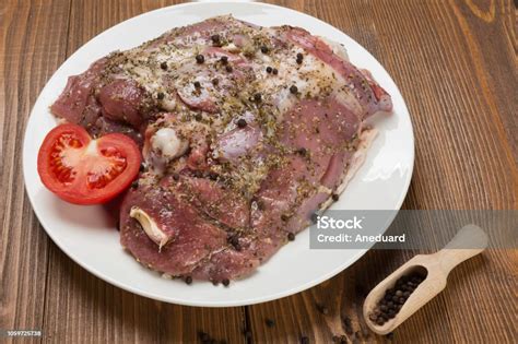 둘러싸인 나무 보드에 흩어져 고추 슬라이스 토마토 옆 흰색 접시에 향신료와 함께 절인된 칠면조 고기 0명에 대한 스톡 사진 및