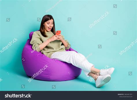 Full Body Girl Holding Phone In Beanbag Over 25 Royalty Free