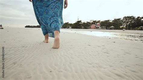 Vidéo Stock Naked legs in a long blue dress The girl walks and then
