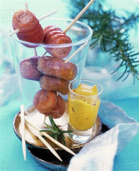 Bacon Wrapped Cocktail Sausages On Cocktail Sticks Mustard Stock