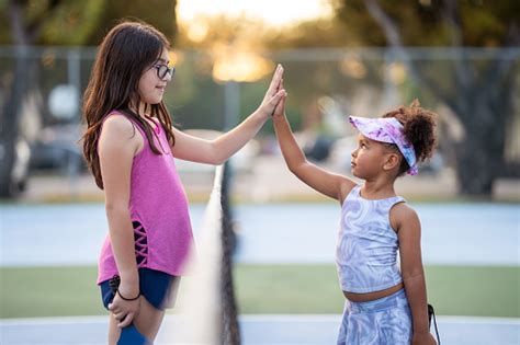 Two Hispanic Girls Give Each Other High Five After Finishing A Pickle
