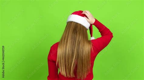 Teenager Girl With Christmas Hat On Back Position Looking Back While