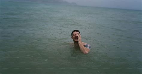 흐린 날 바다에서 수영하는 남자 사진 Unsplash의 대양 이미지