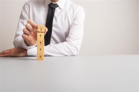 Premium Photo Businessman Stacking Wooden Blocks With Upward Pointing Arrows On Them With The