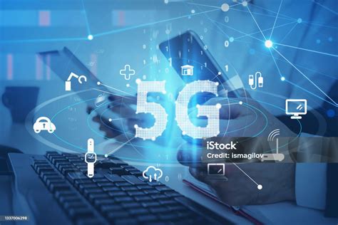 스마트폰을 포함한 디지털 기기로 작업하는 두 명의 동료와 함께 사무실 작업장 5g 디지털 네트워크의 블루 홀로그램 아이콘 무선 시스템 및 고속 신호 2명에 대한 스톡 사진
