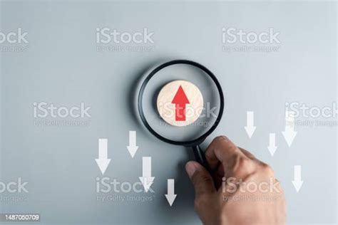 돋보기를 들고 있는 손은 빨간색 화살표에 초점을 맞추고 다른 방향은 비즈니스 중단 및 기술 혁신 및 다른 사고 아이디어 개념을