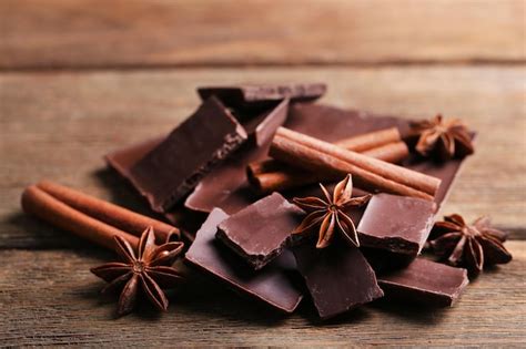 Premium Photo Black Chocolate Pieces With Spices On Wooden Background