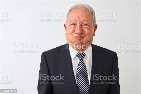 재미 있는 얼굴과 고립 된 흰색 배경 퍼핑 뺨 위에 서 양복을 입고 선임 회색 머리 사업가 공기 미친 표정으로 입이 팽창 가득