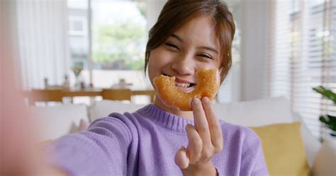 젊은 Vlogger 아시아 사람들 영향력있는 소녀 사진을 찍어 인스 타 그램 Tiktok 릴 응용 프로그램에서 물린 웃는 도넛
