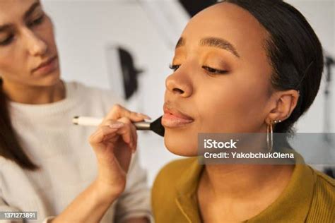 촬영 전 다인종 모델에 화장품을 적용하는 진지한 메이크업 아티스트 메이크업 화장품에 대한 스톡 사진 및 기타 이미지 메이크업 화장품 스튜디오 촬영 휴대폰 앱 Istock