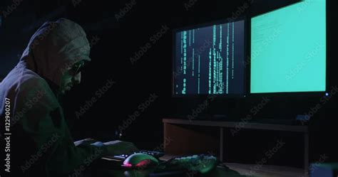 Cyber Terror Computer Hacker Sitting In A Dark Room In Front Of