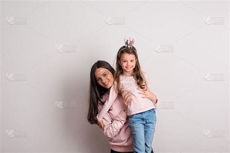 一个戴着头巾的小女孩和她的母亲站在画室里。