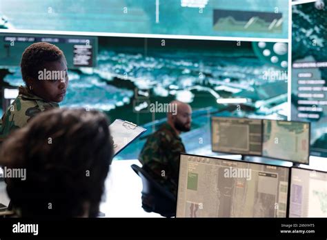 Female Trooper Checking Real Time Battlefield Data In Command Post Control Room Examining