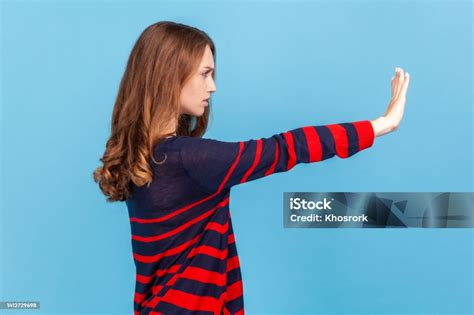 블록 스톱 제스처를 보여주는 줄무늬 캐주얼 스타일 스웨터를 착용하고 괴롭힘과 폭력을 뒤로 물러서게하는 겁에 질린 심각한 젊은