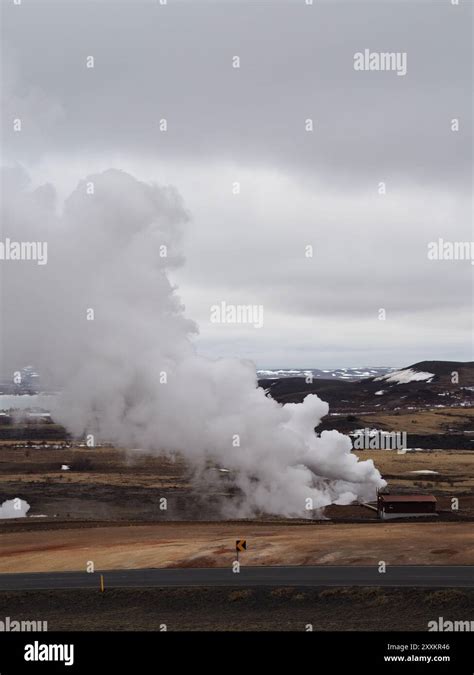 Clouds Of Steam Ascending From A Geothermal Plant Amidst A Rugged Landscape Highlighting The
