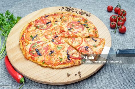 소시지 치즈 올리브 토마토 조각을 반지로 자른 피자 밝은 나무 접시에 피자 피자는 조각으로 잘라 하나는 다른 사람에서 밀어 0